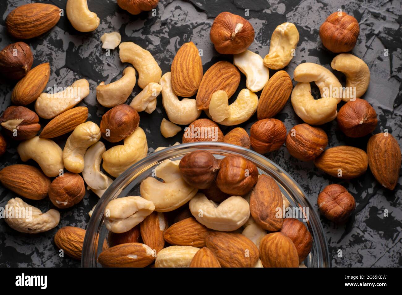 mixed different raw cocktail nuts in a bowl on a dark table, healthy ...