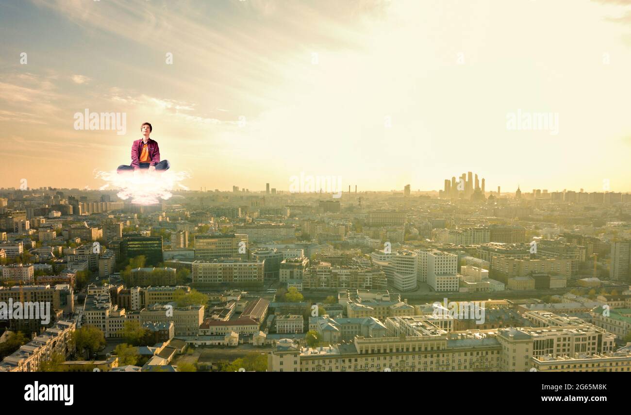 person meditationg or flying on the cloud above the urban landscape ...