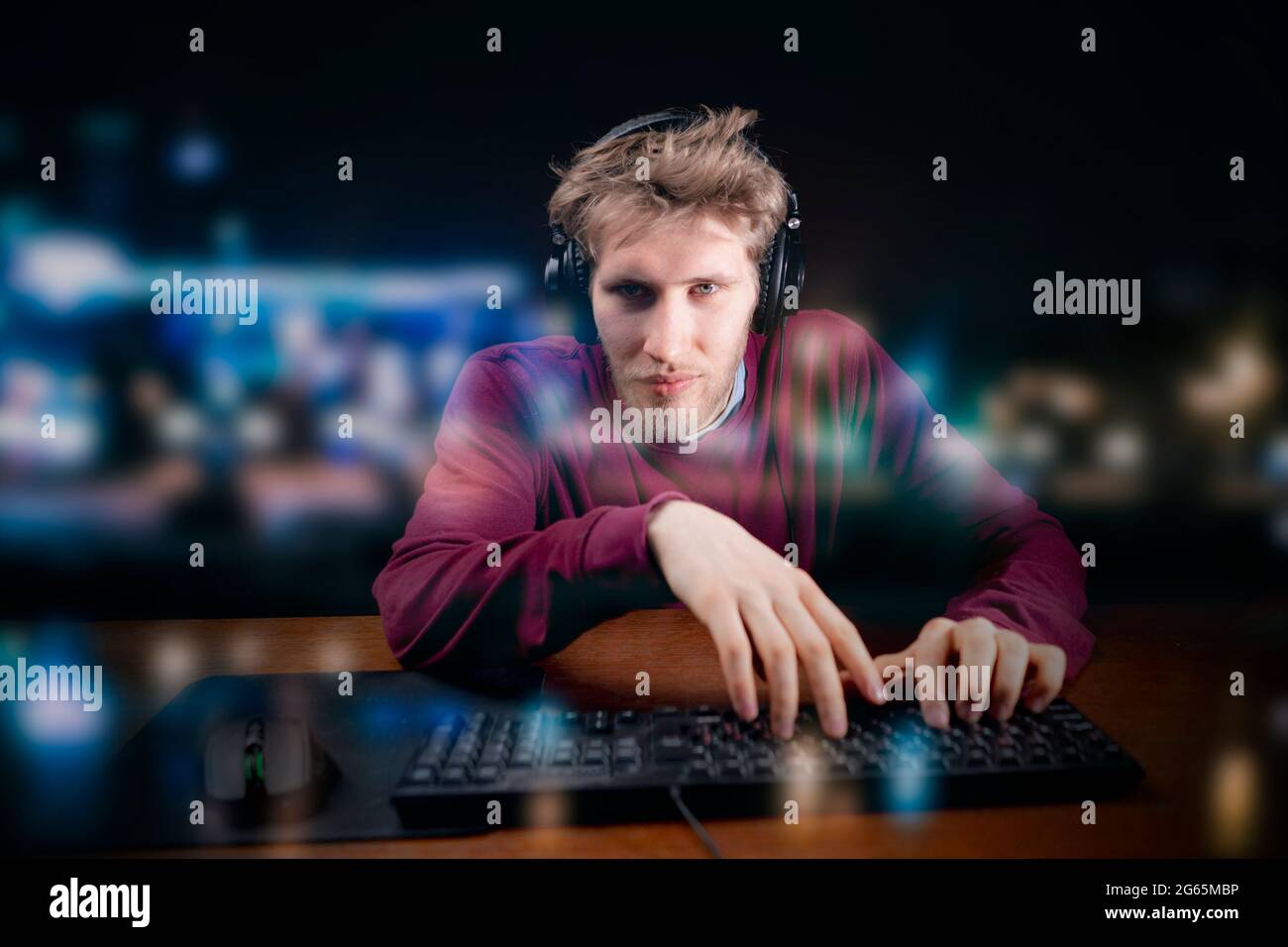 young male playing computer video games on a table in a dark room Stock ...