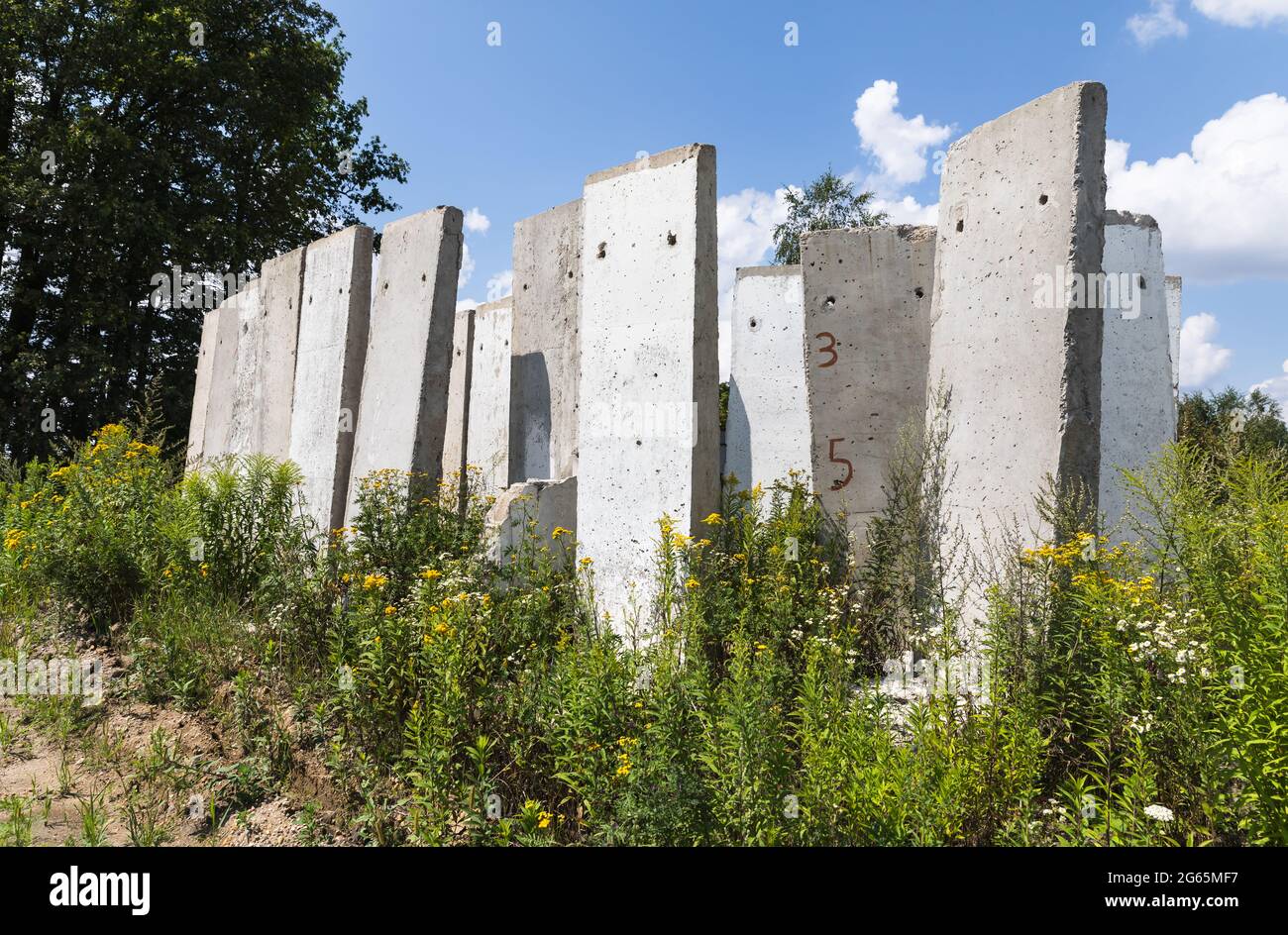 Old concrete slabs standing on a summer sunny day in the field. Old ...
