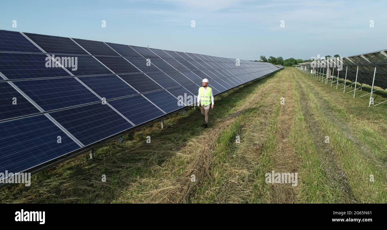 Solar power engineer working on a solar farm. Drone shot Stock Photo ...