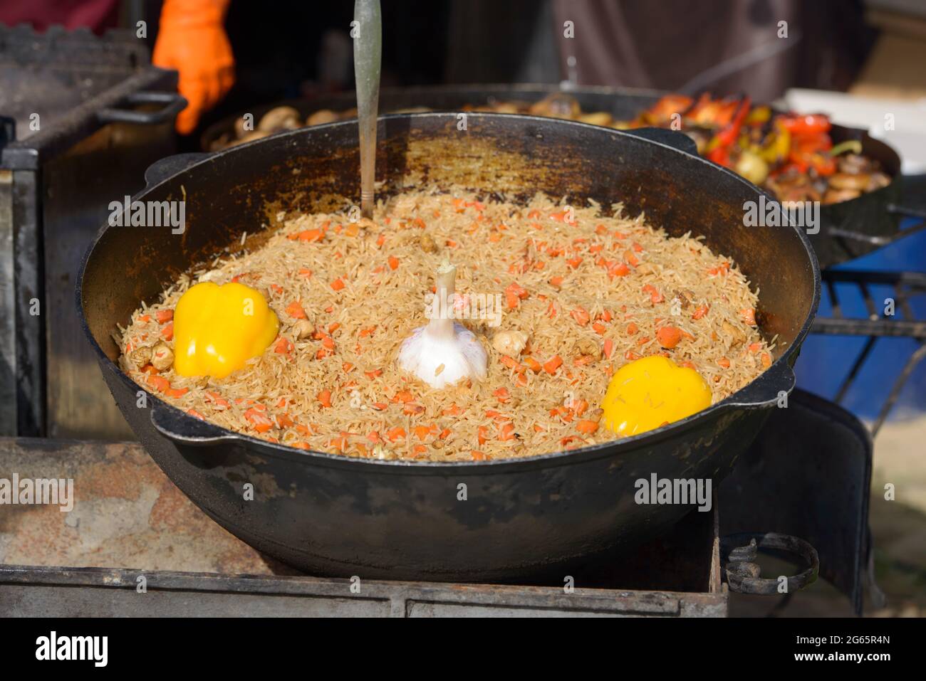Cooking of traditional pilaf in big cauldron, street food in outdoor ...