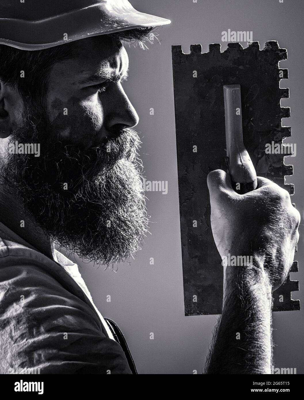 Bearded man worker, beard, building helmet, hard hat. Plastering tools ...