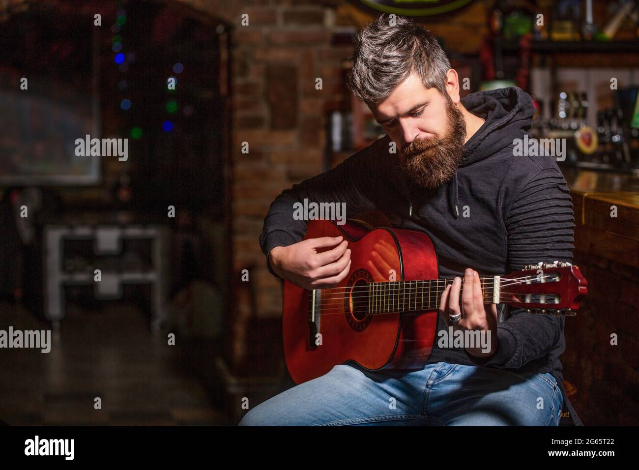 Bearded guitarist plays. Play the guitar. Beard hipster man sitting in ...