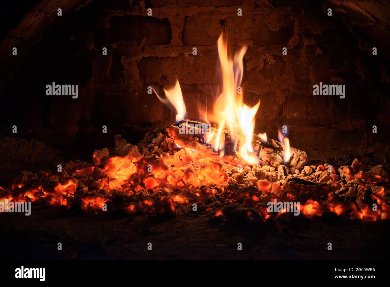 Logs of firewood burn out in the oven. Coals and flames in the ...