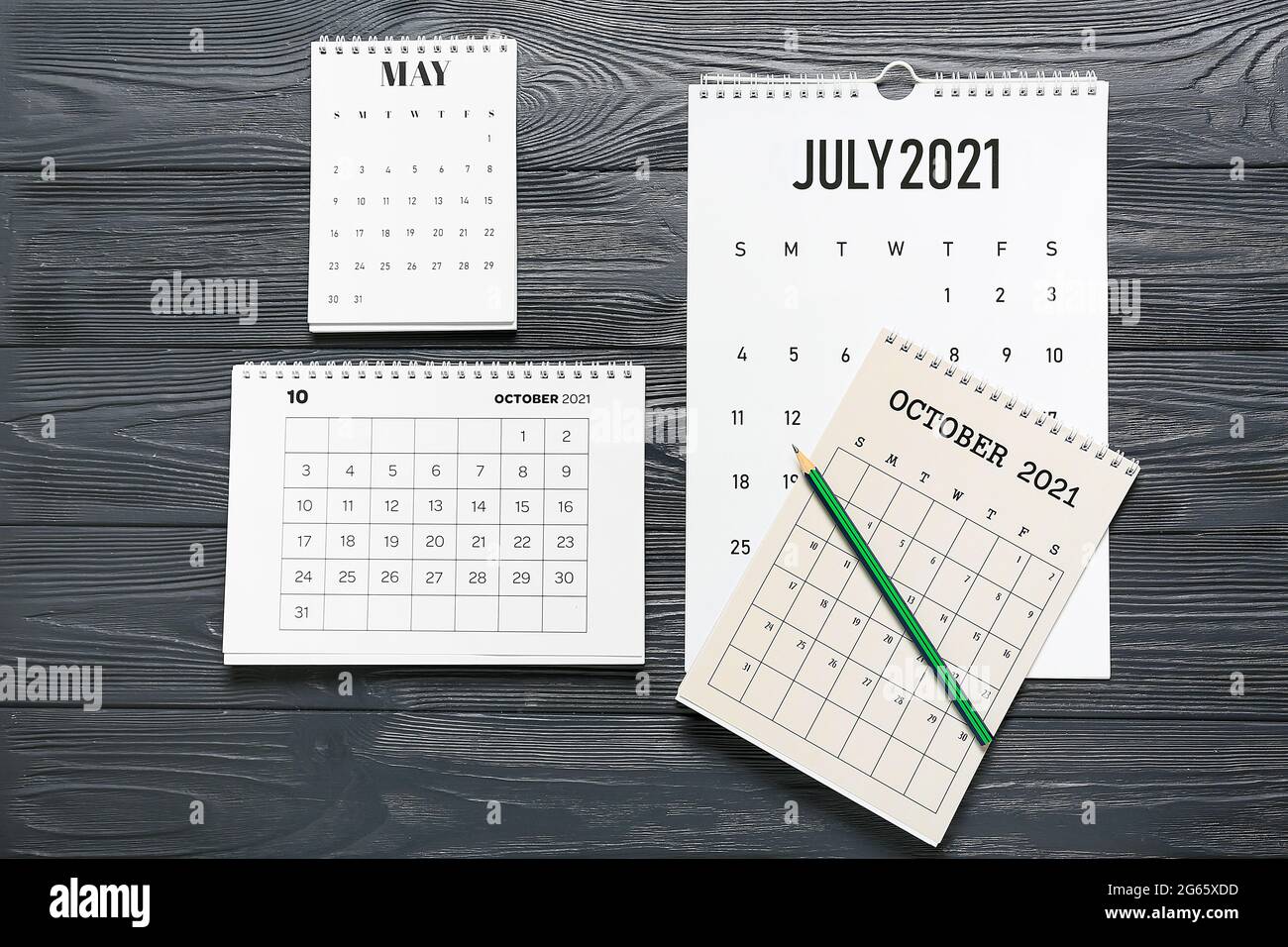 Flip paper calendars and pencil on dark wooden background Stock Photo ...