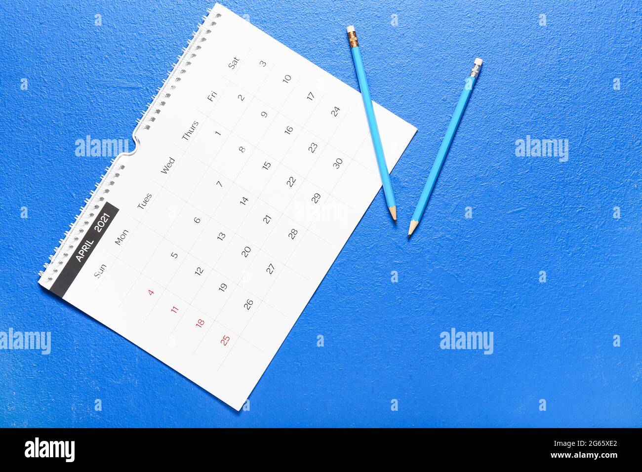 Flip paper calendar and pencils on color background Stock Photo - Alamy