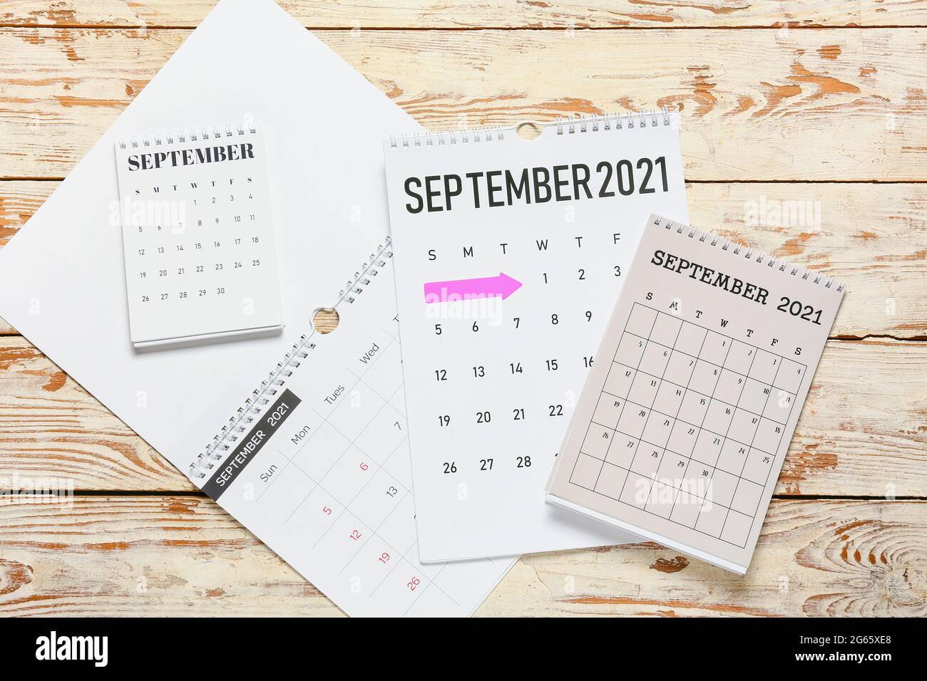 Flip paper calendars on light wooden background Stock Photo - Alamy