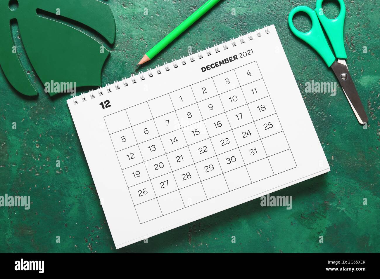 Flip paper calendar, pencil and scissors on color background Stock ...