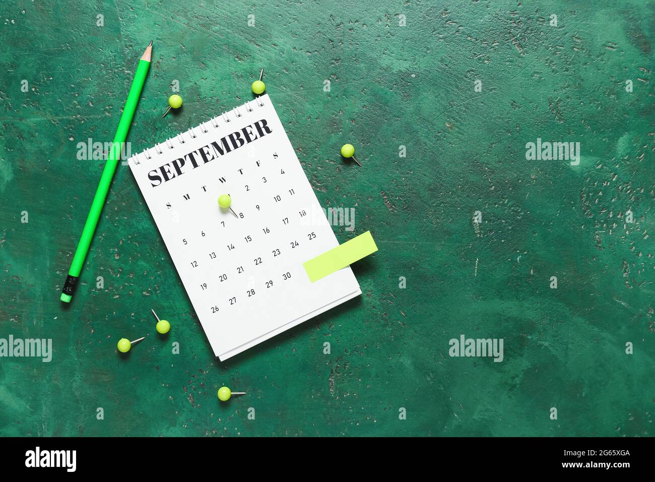 Flip paper calendar, pencil and pins on color background Stock Photo ...