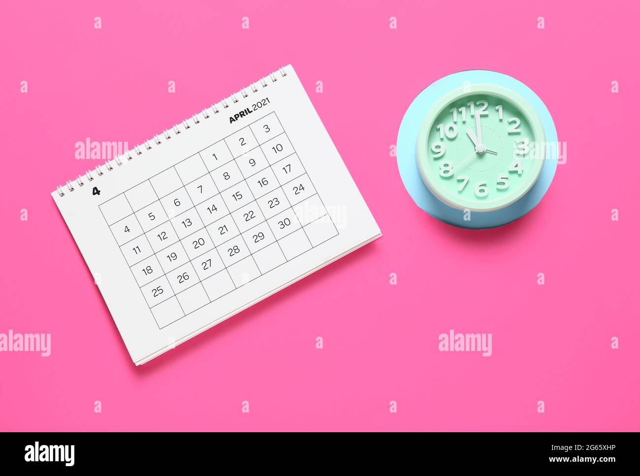 Flip paper calendar and alarm clock on color background Stock Photo - Alamy