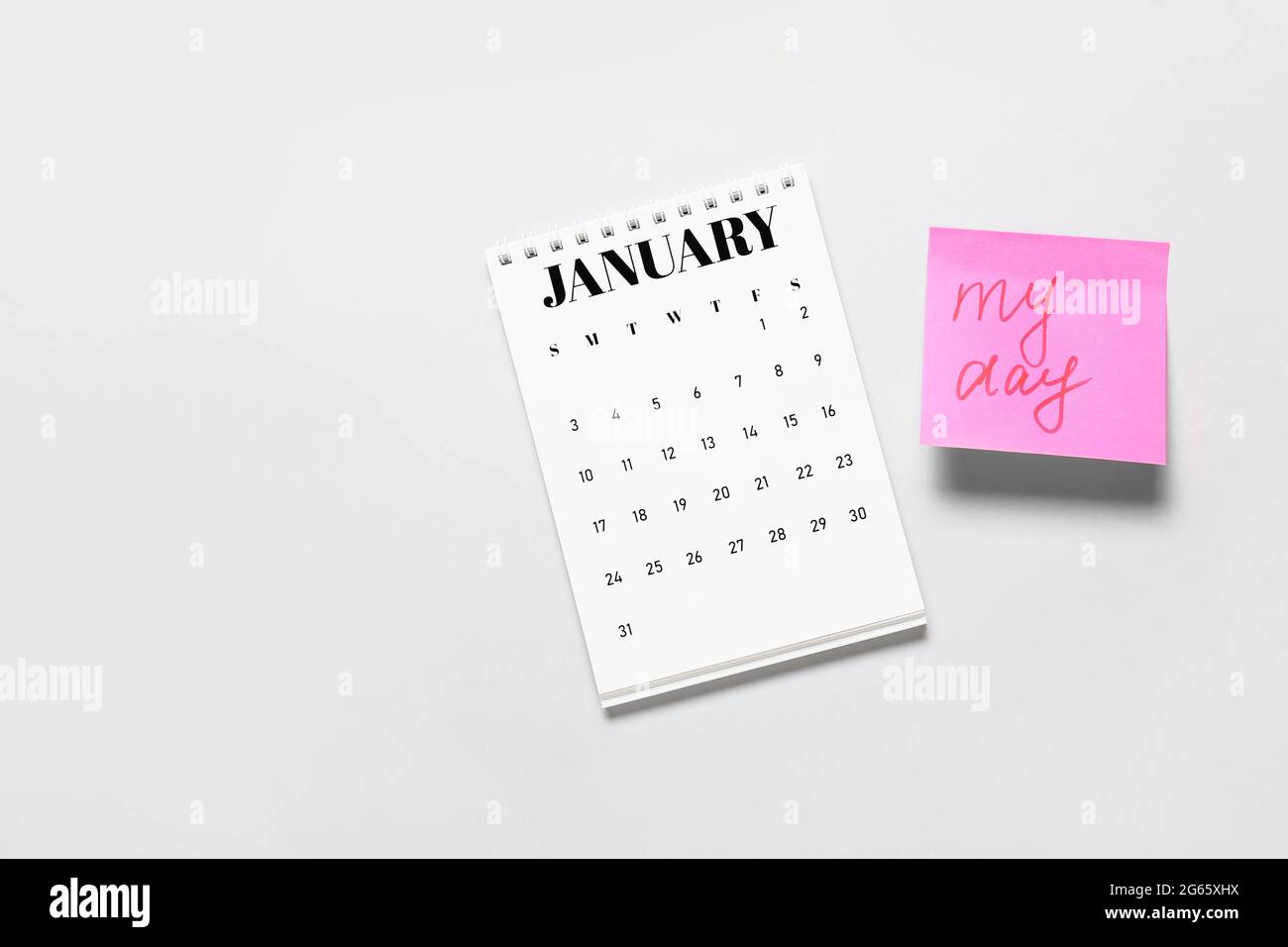 Flip paper calendar and sheet of paper with text MY DAY on light ...