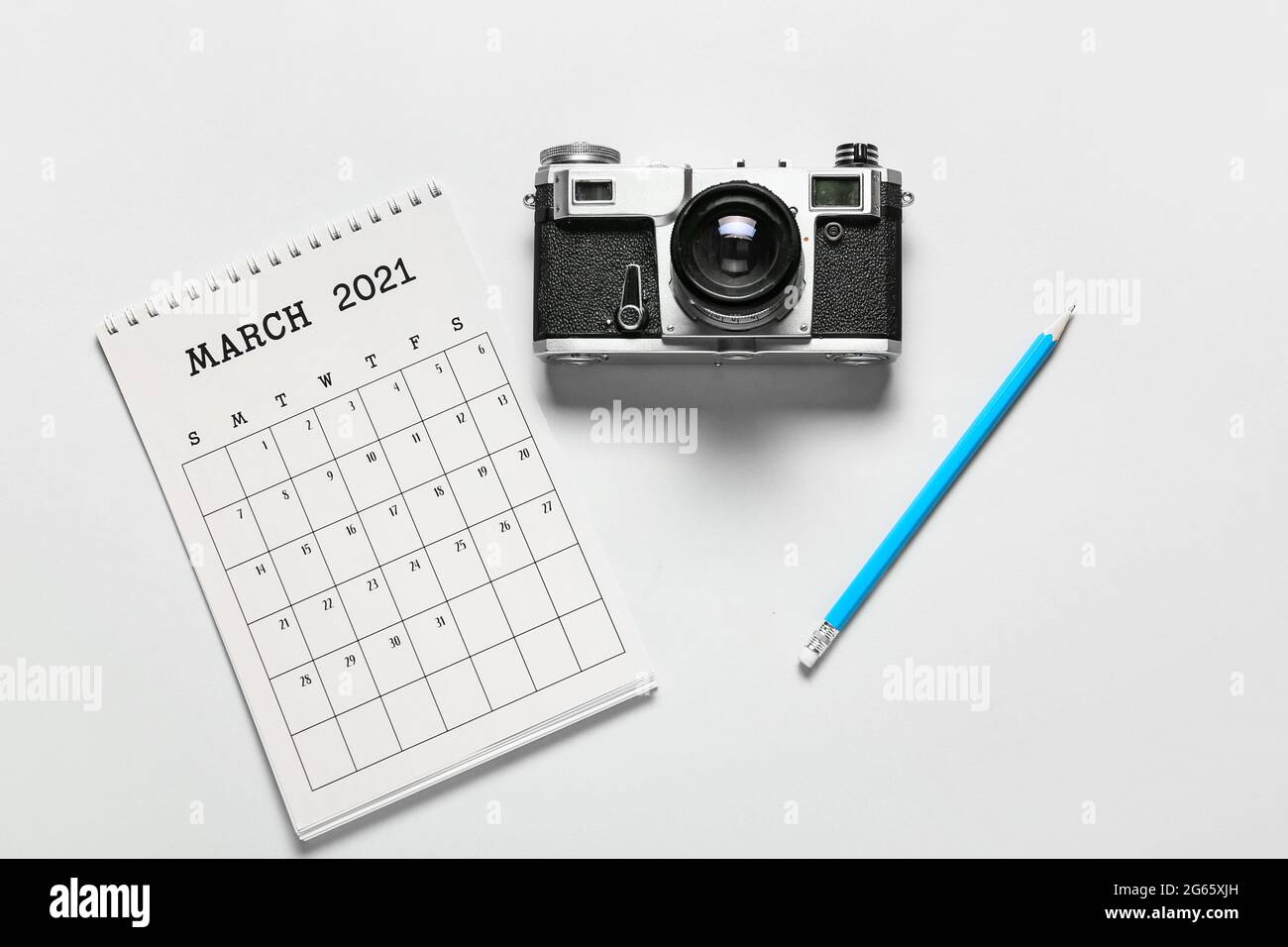 Flip paper calendar, photo camera and pencil on light background Stock ...