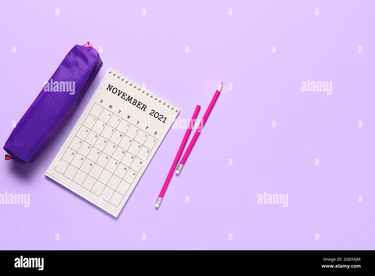 Flip paper calendar, pencils and case on color background Stock Photo ...