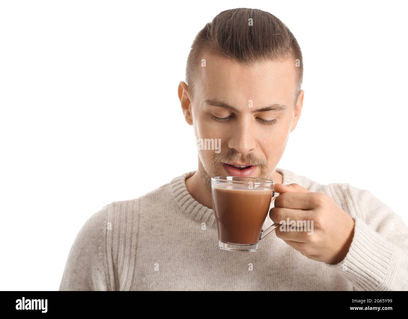 Handsome man drinking hot cocoa on white background Stock Photo - Alamy