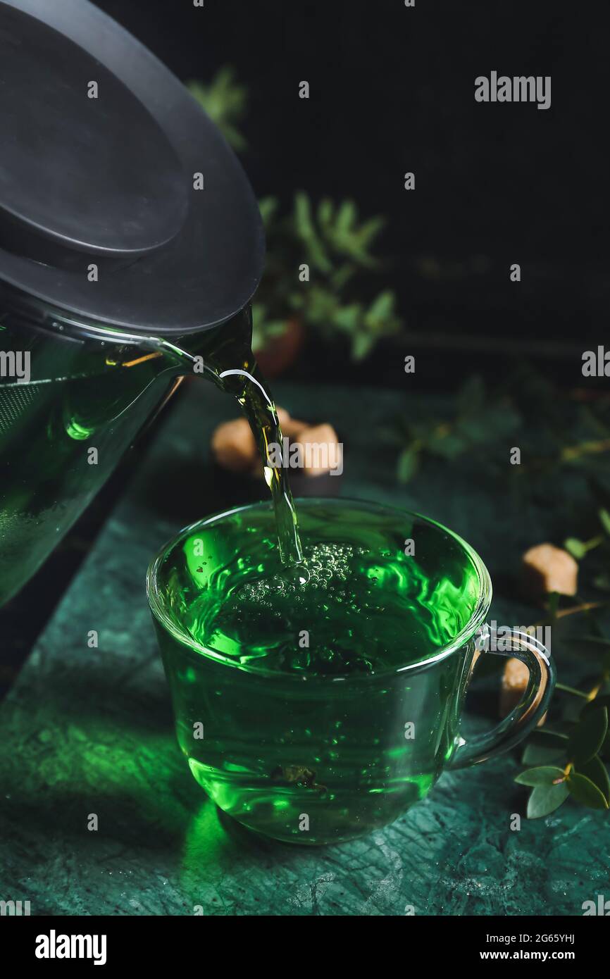 Pouring of hot green tea in cup on table Stock Photo - Alamy