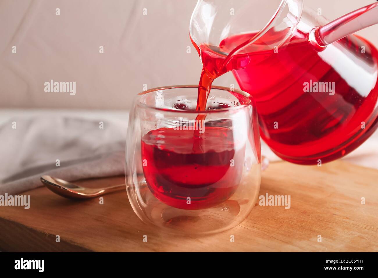 Pouring of hot red tea in glass on table Stock Photo - Alamy