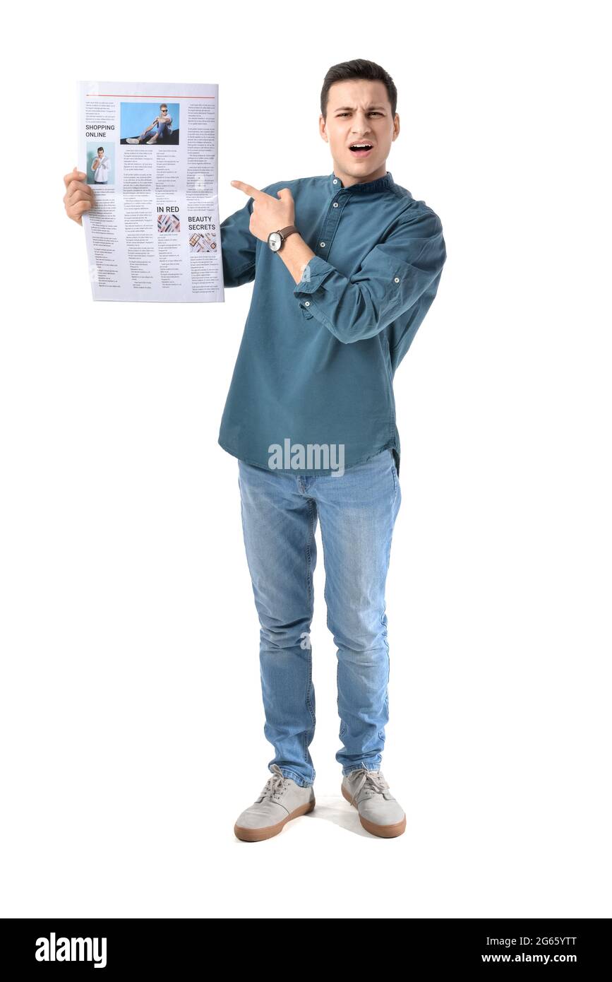Upset young man pointing at newspaper on white background Stock Photo ...
