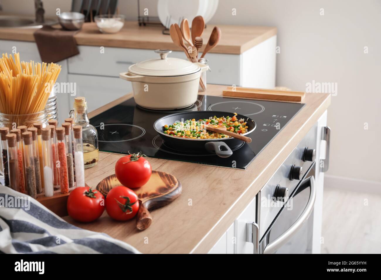 Modern electric stove and utensils in kitchen Stock Photo - Alamy