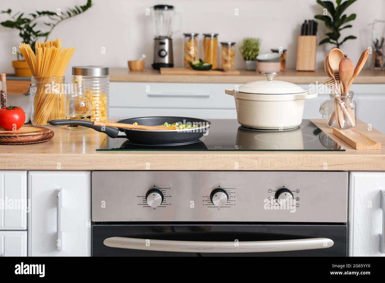 Modern electric stove and utensils in kitchen Stock Photo - Alamy