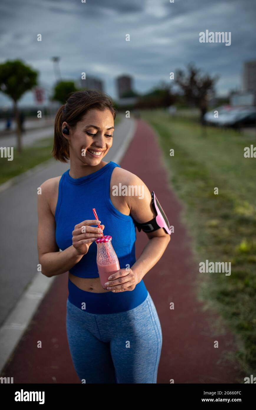 Athlete drinkging strawberry smoothie relaxing after practice. Young ...