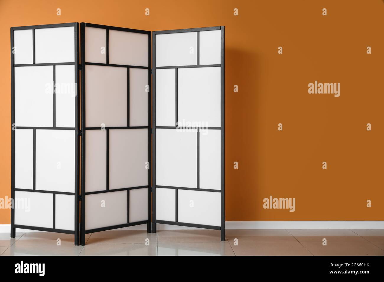 Modern folding screen near color wall Stock Photo - Alamy
