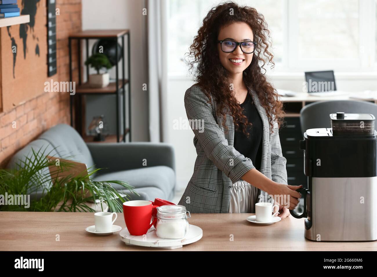 Beautiful young woman making coffee in kitchen Stock Photo - Alamy