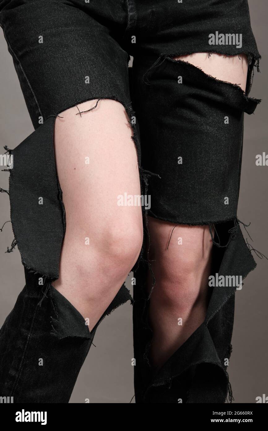 beautiful slim female legs in ripped jeans close up Stock Photo - Alamy
