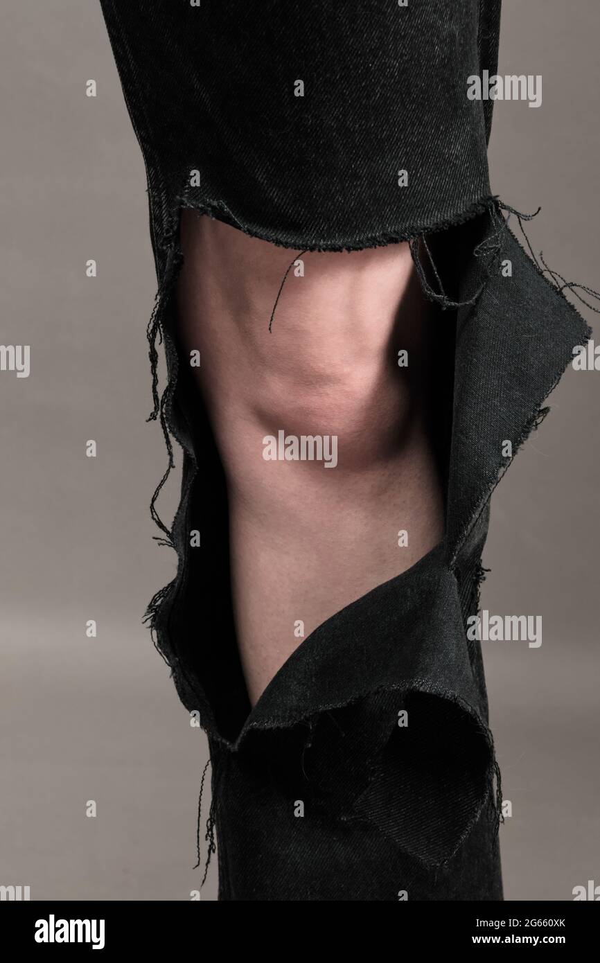 beautiful slim female leg in ripped jeans close up Stock Photo - Alamy