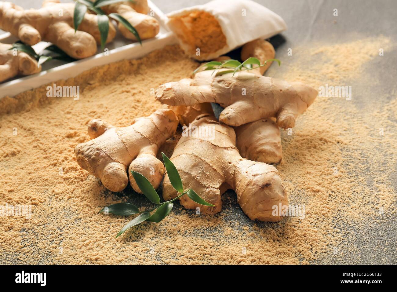 Ginger powder and roots on dark background Stock Photo - Alamy