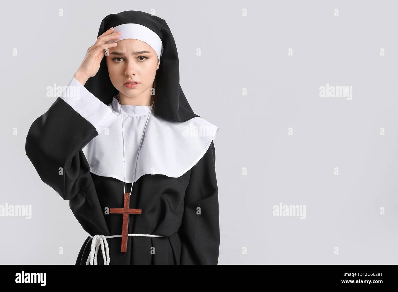 Young sad nun on light background Stock Photo - Alamy