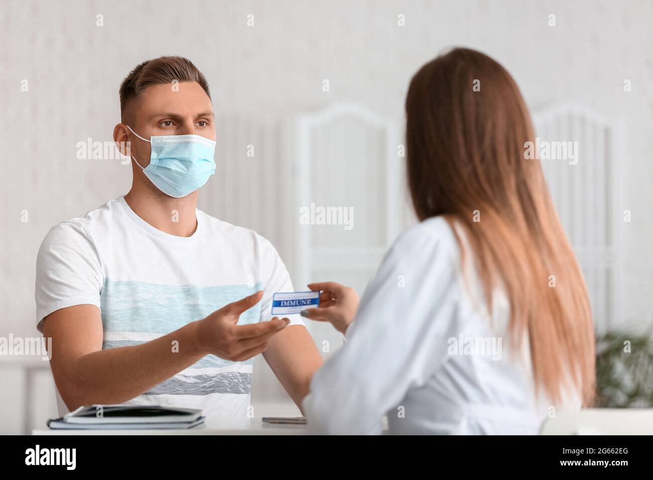 Doctor giving patient his immune card in clinic Stock Photo - Alamy