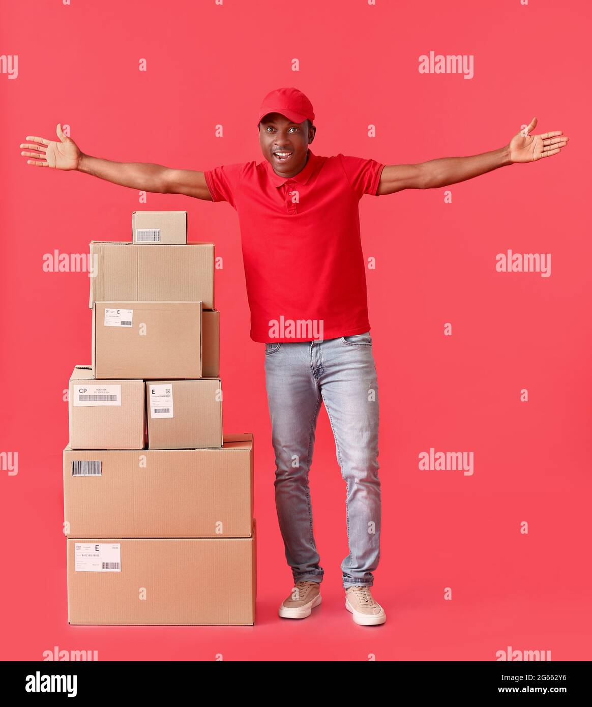 African-American delivery man with many parcels on color background ...