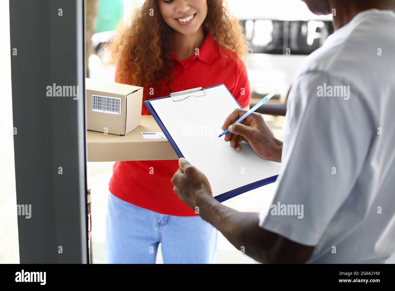 Customer receiving parcel from courier Stock Photo - Alamy