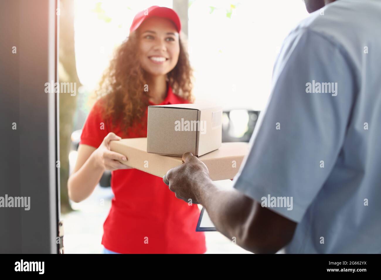 Customer receiving parcel from courier Stock Photo - Alamy