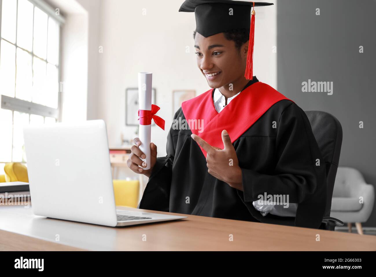 Happy African-American student on his graduation day at home. Concept ...