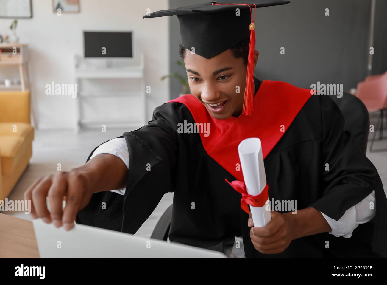 Happy African-American student on his graduation day at home. Concept ...
