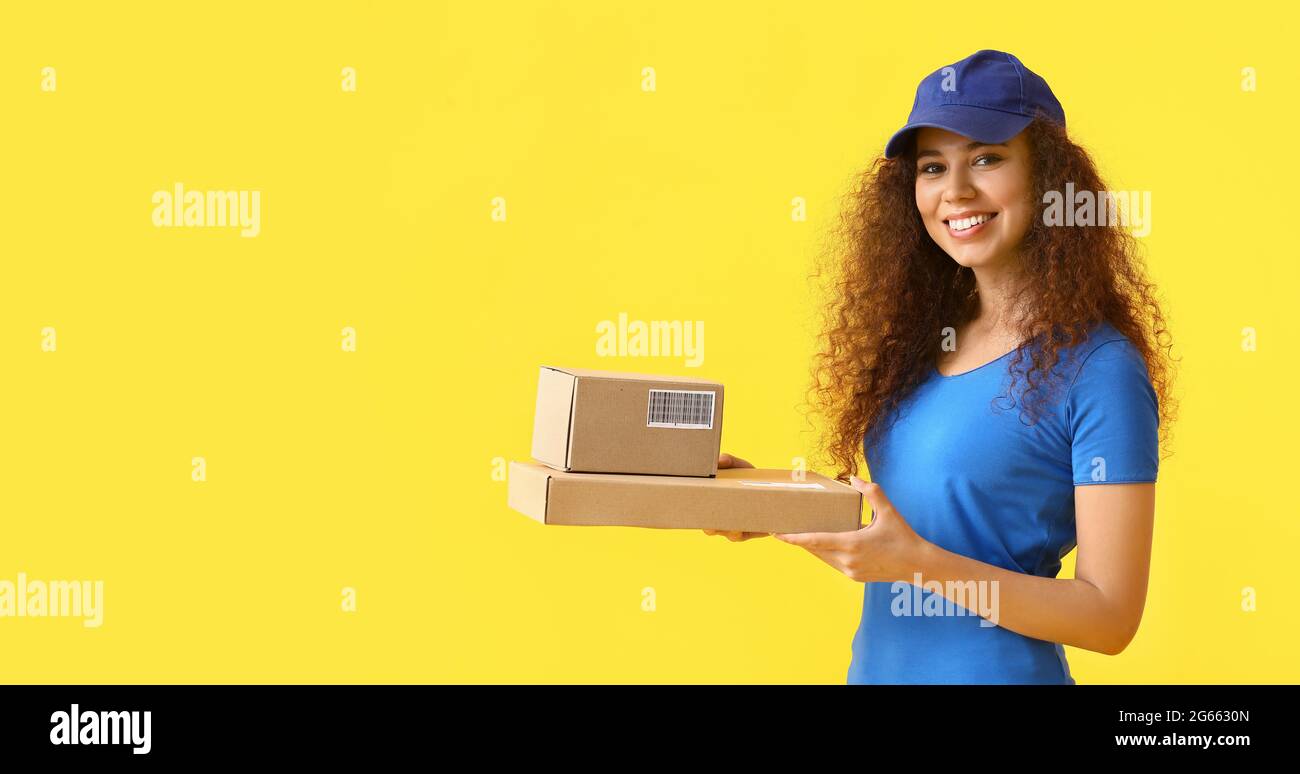 Female African-American courier with parcels on color background Stock ...