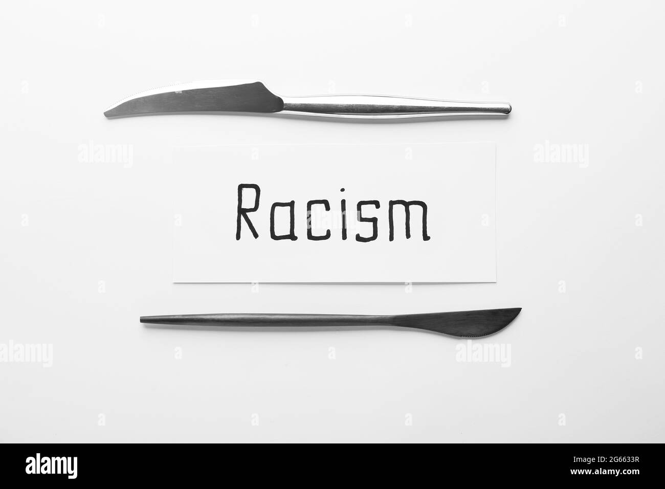 Paper piece with word RACISM and knives on white background Stock Photo ...