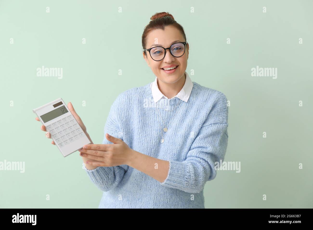 Portrait of female teacher with calculator on color background Stock ...