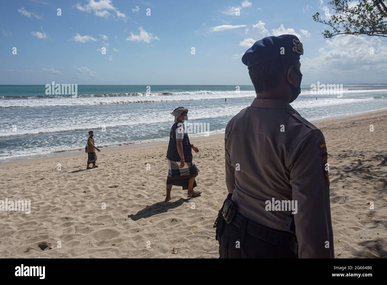 Badung, Bali, Indonesia. 3rd July, 2021. A police offier and Balinese ...
