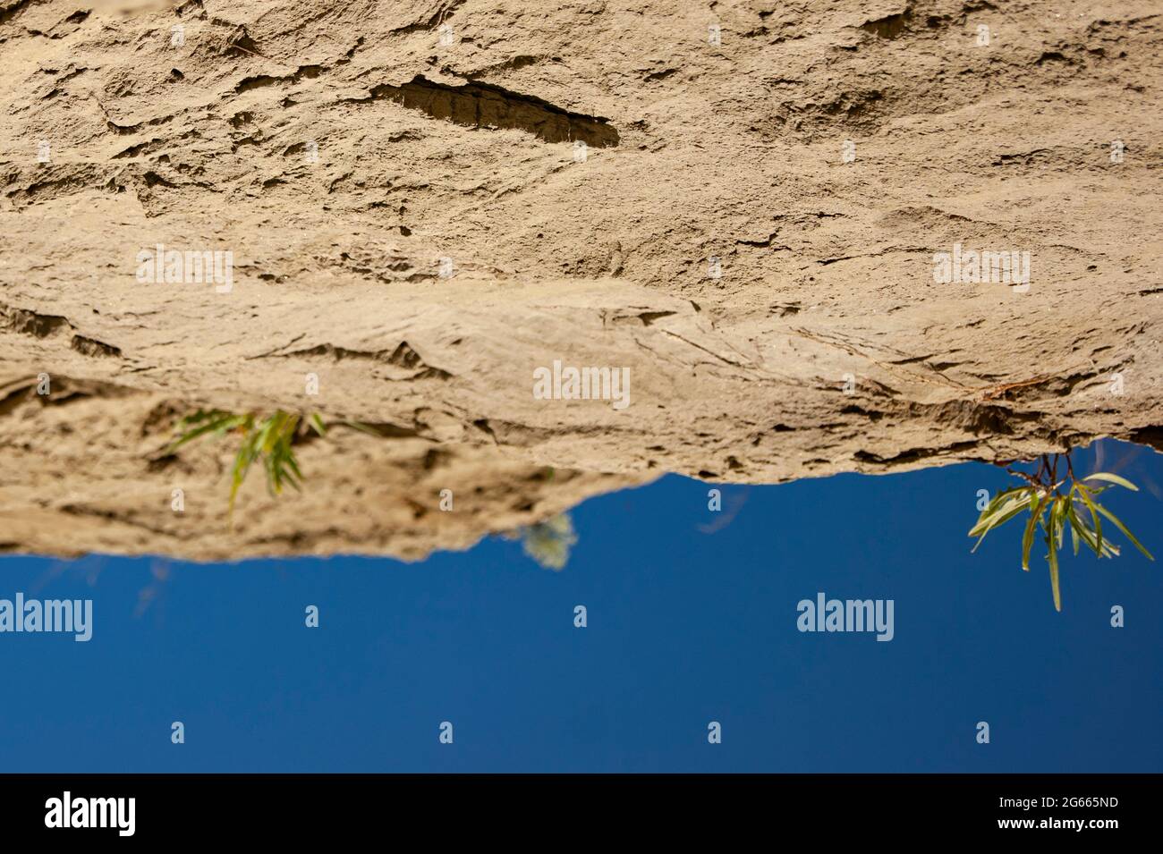Sand cliffs against the blue sky. Bright sand texture. The rough and ...