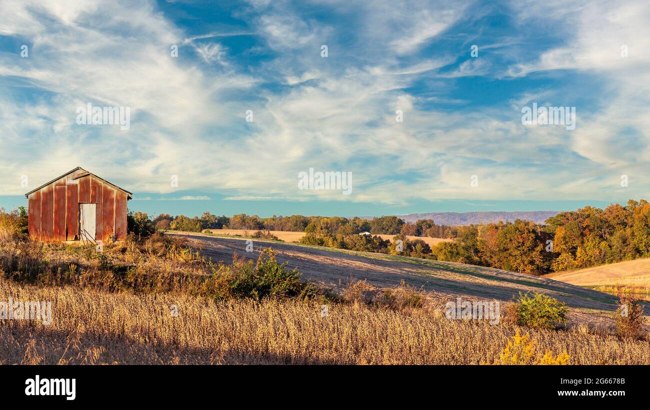 Landscape of an old barn on hilly farm fields under a cloudy sky Stock ...