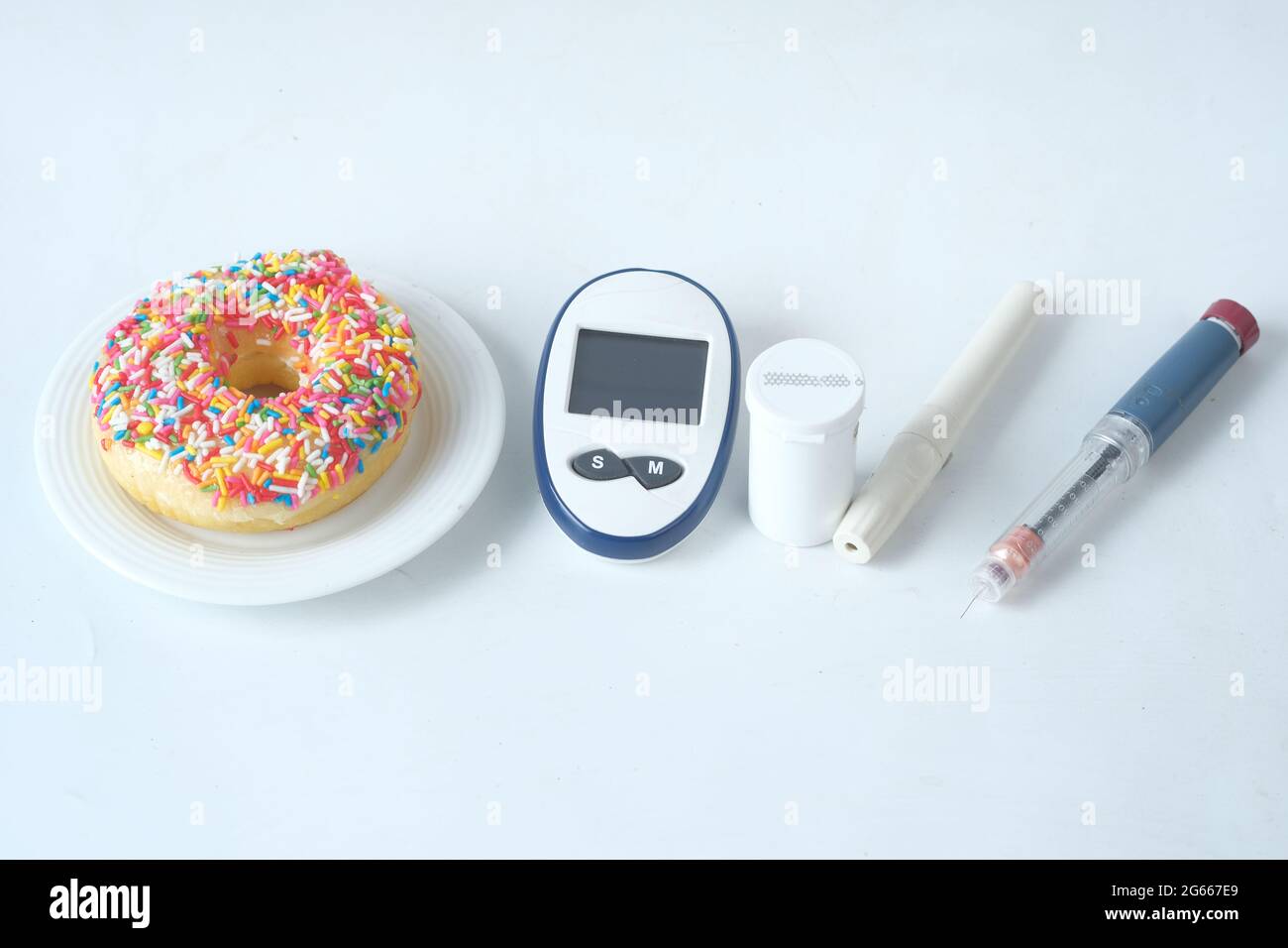 diabetic measurement tools, insulin and donuts on white background ...