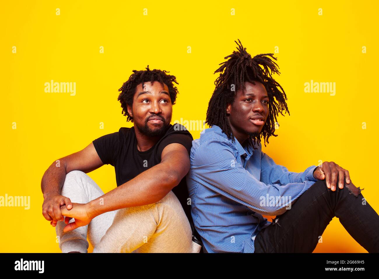 two african american guys posing cheerful together on yellow background ...