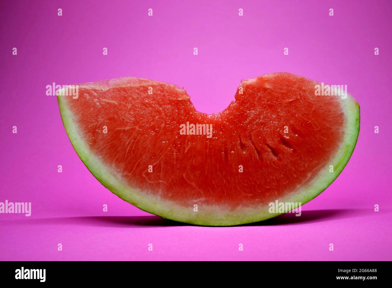 Fresh bitten watermelon slice isolated over pink background Stock Photo ...
