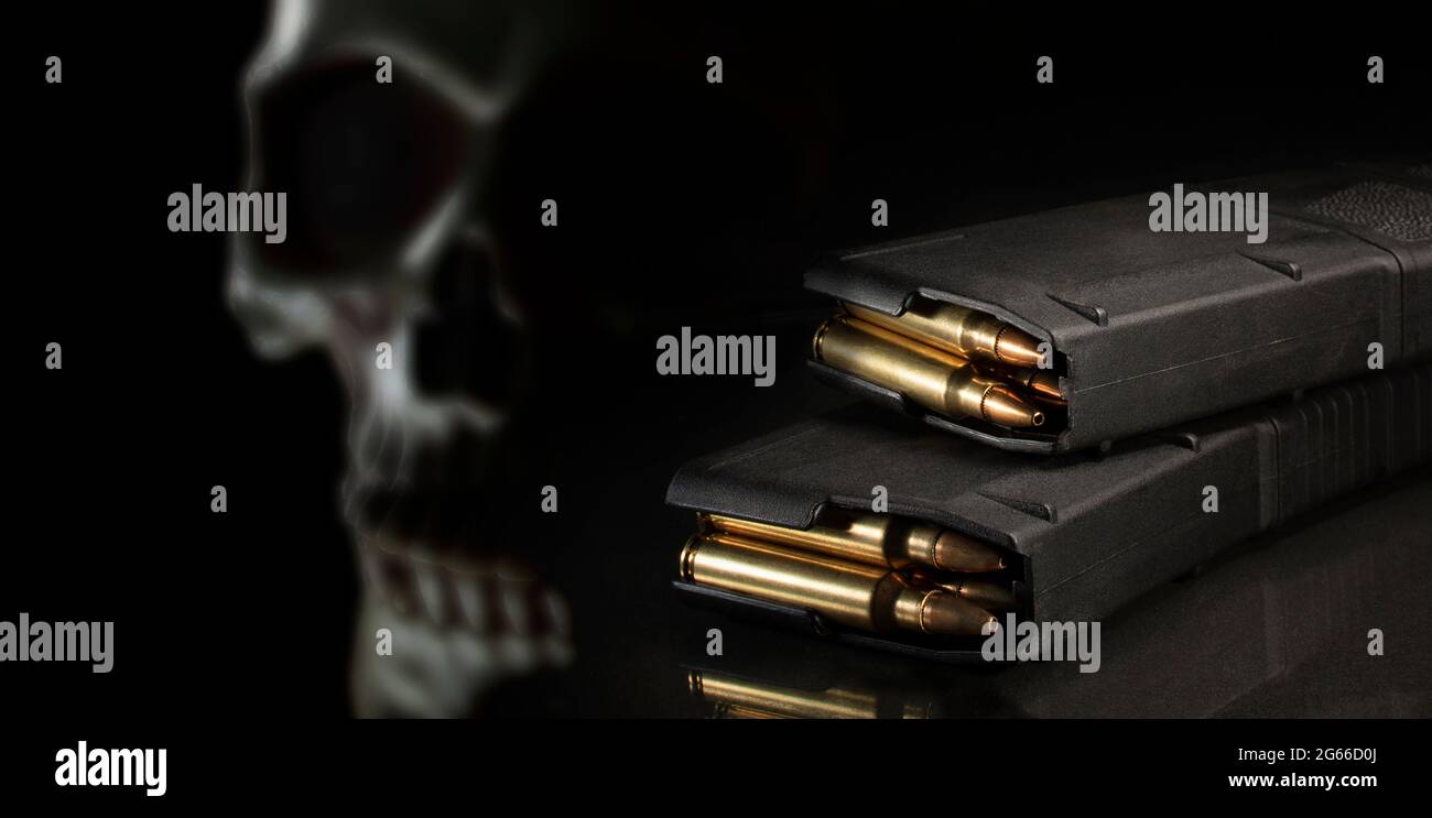 Human skull in the background with loaded 30-fourn magazines for an ...