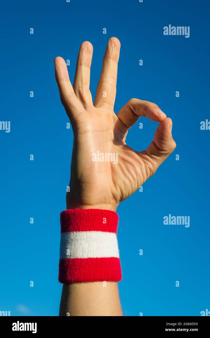 Japanese athlete wearing red and white colored wristbands making okay ...