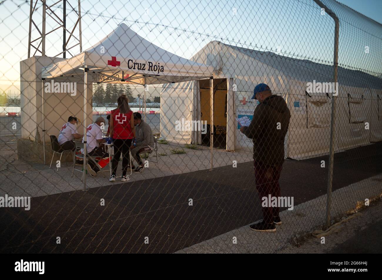 Migrants are seen chatting with a member of Spanish Red Cross through a ...