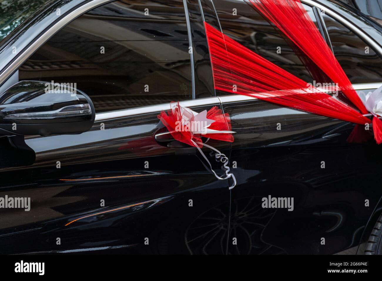 Black wedding car, red organza fabric, ribbon bow Stock Photo - Alamy